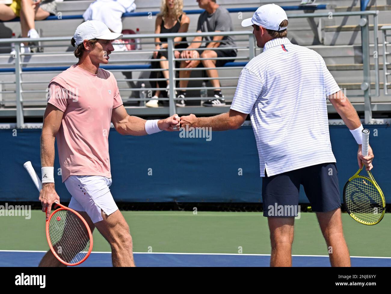 Robert Galloway and Alex Lawson fist bump during a men's doubles match ...