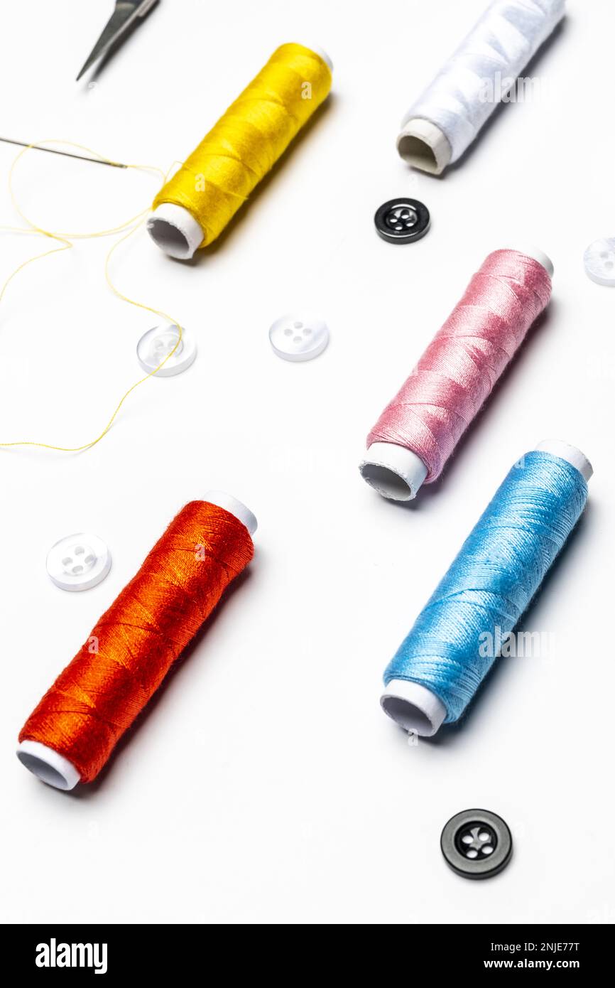 Set of spools of colored thread with a threaded needle, black and white ...