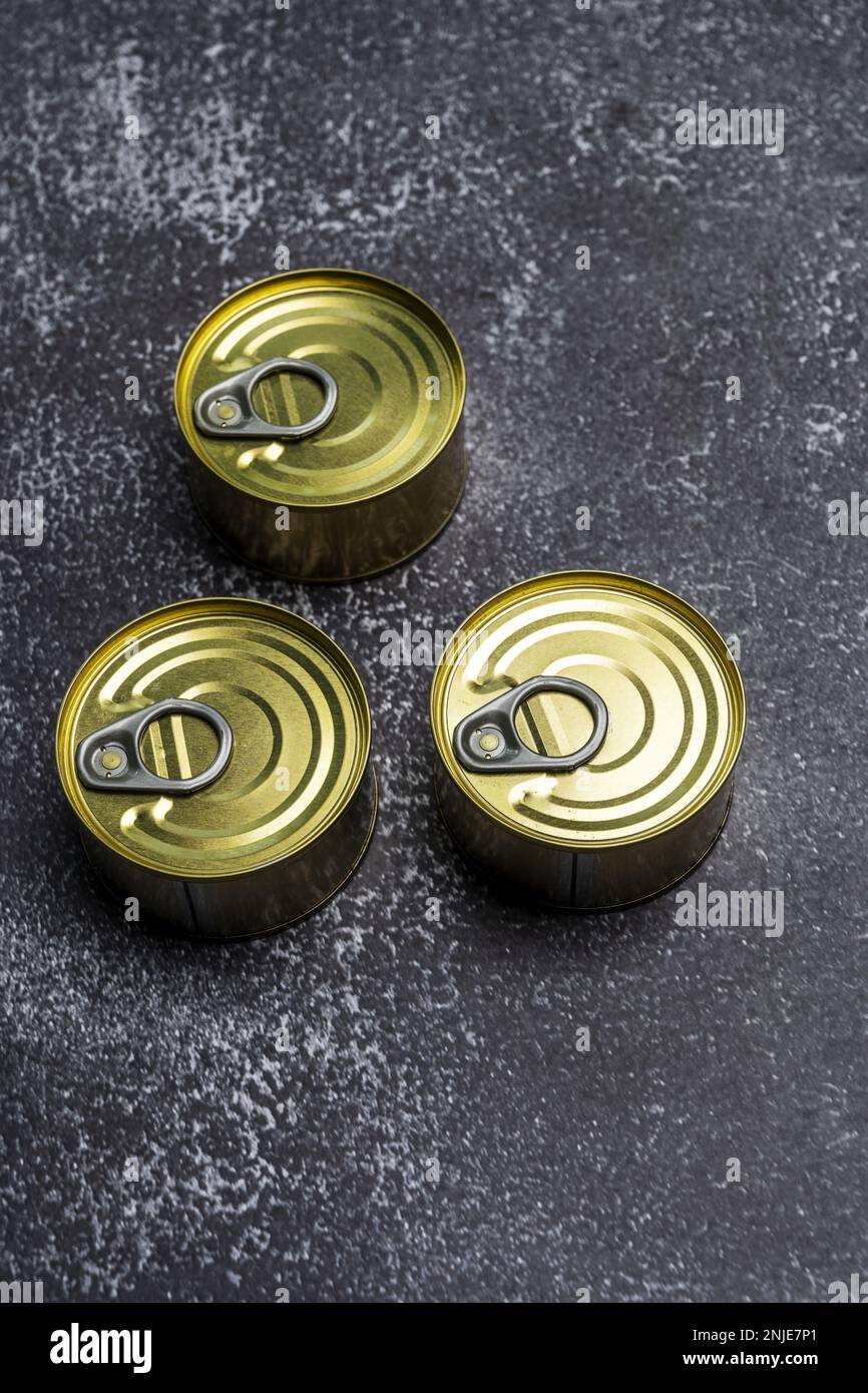 Trio of small metal circular canning tins with easy open pull tabs on ...