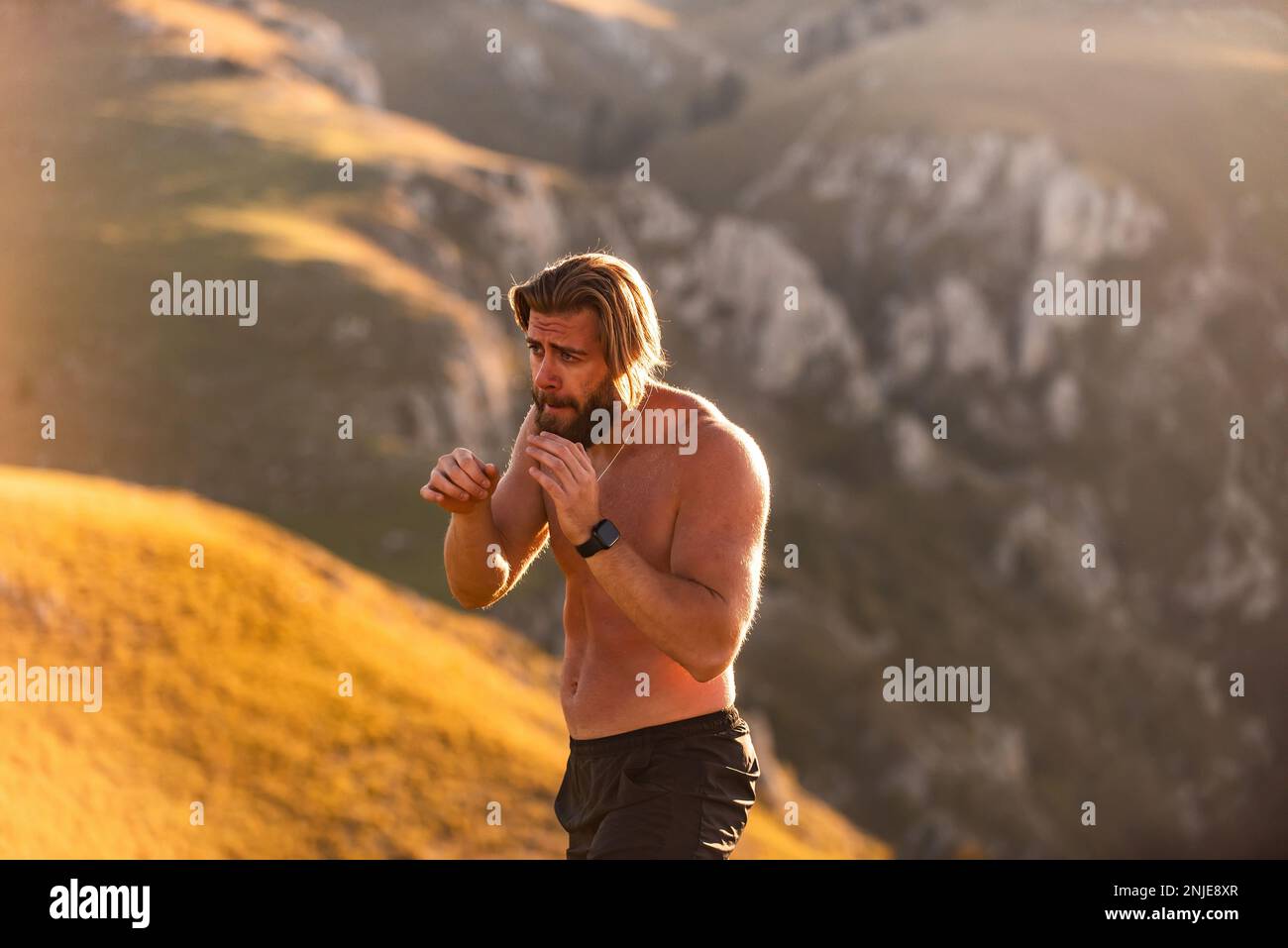 Man boxing with shadow exercising at sunset outdoor. Port victory ...