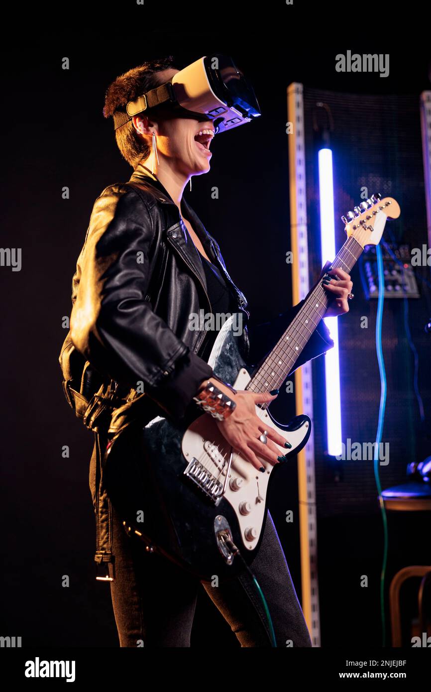 Rebel performer playing heavy metal song using electric guitar while ...