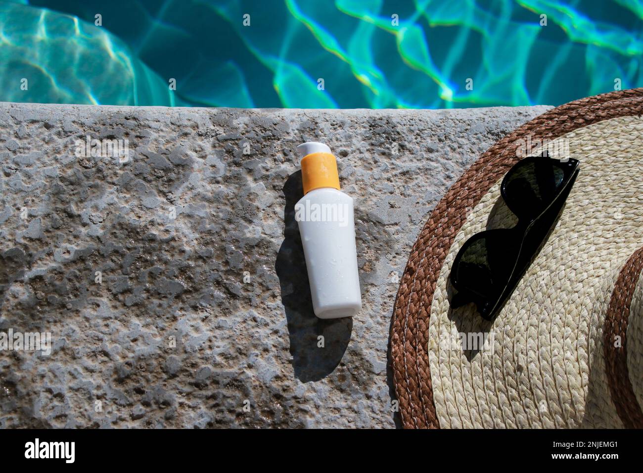 white mock up sunscreen bottle at the pool with sunglasses and summer ...