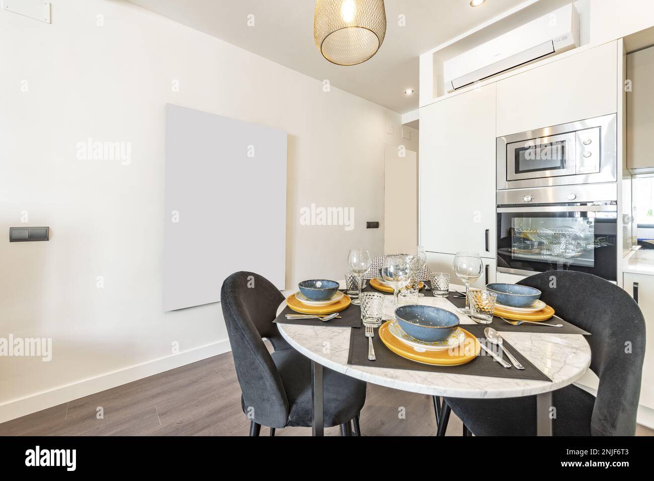 Round white marble dining table surrounded by upholstered chairs in a ...