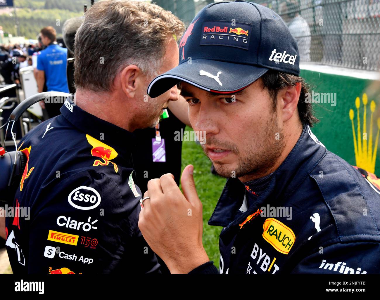 Red Bull driver Sergio Perez of Mexico, right, walks in the pit area ...