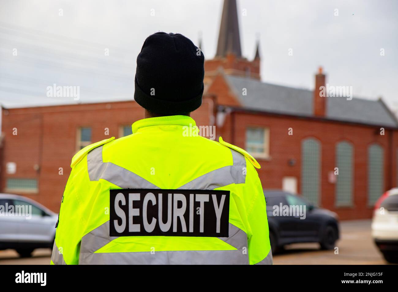 Security guard setting up a caution tape to do parking enforcement at ...