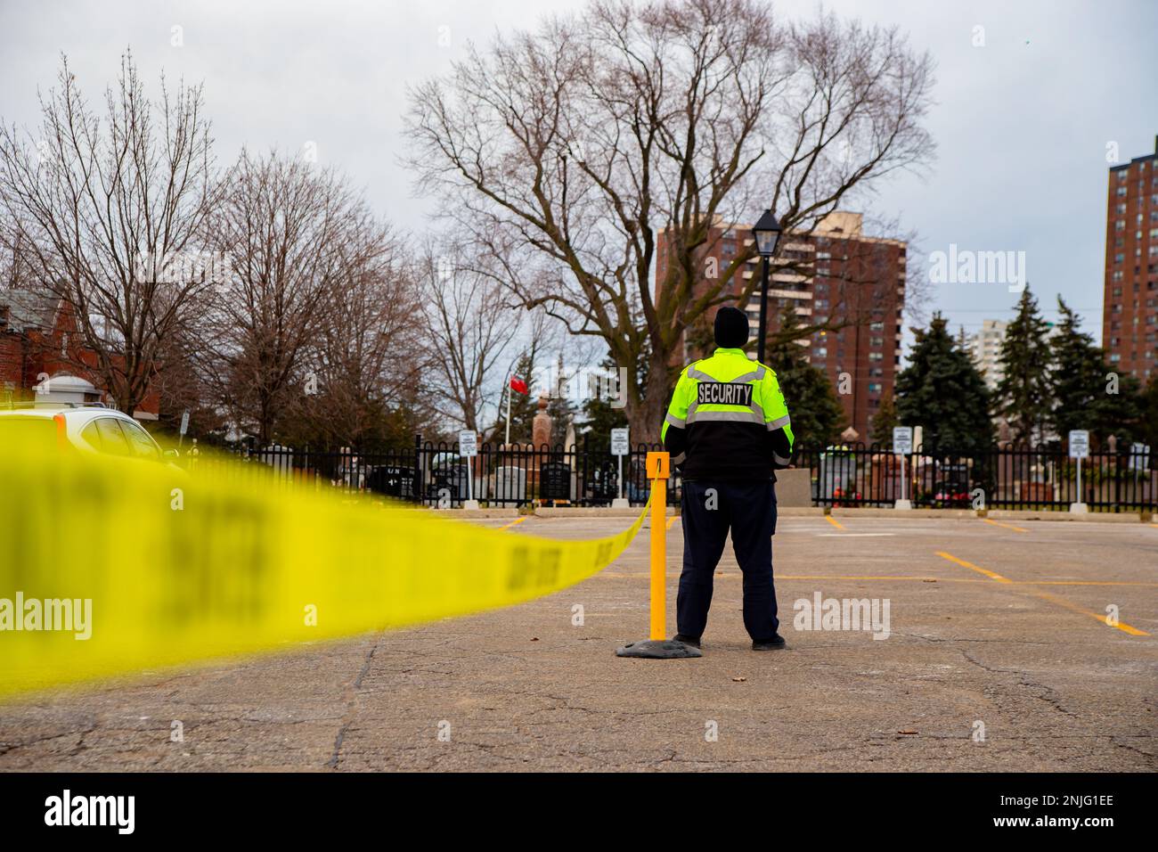Security guard setting up a caution tape to do parking enforcement at ...