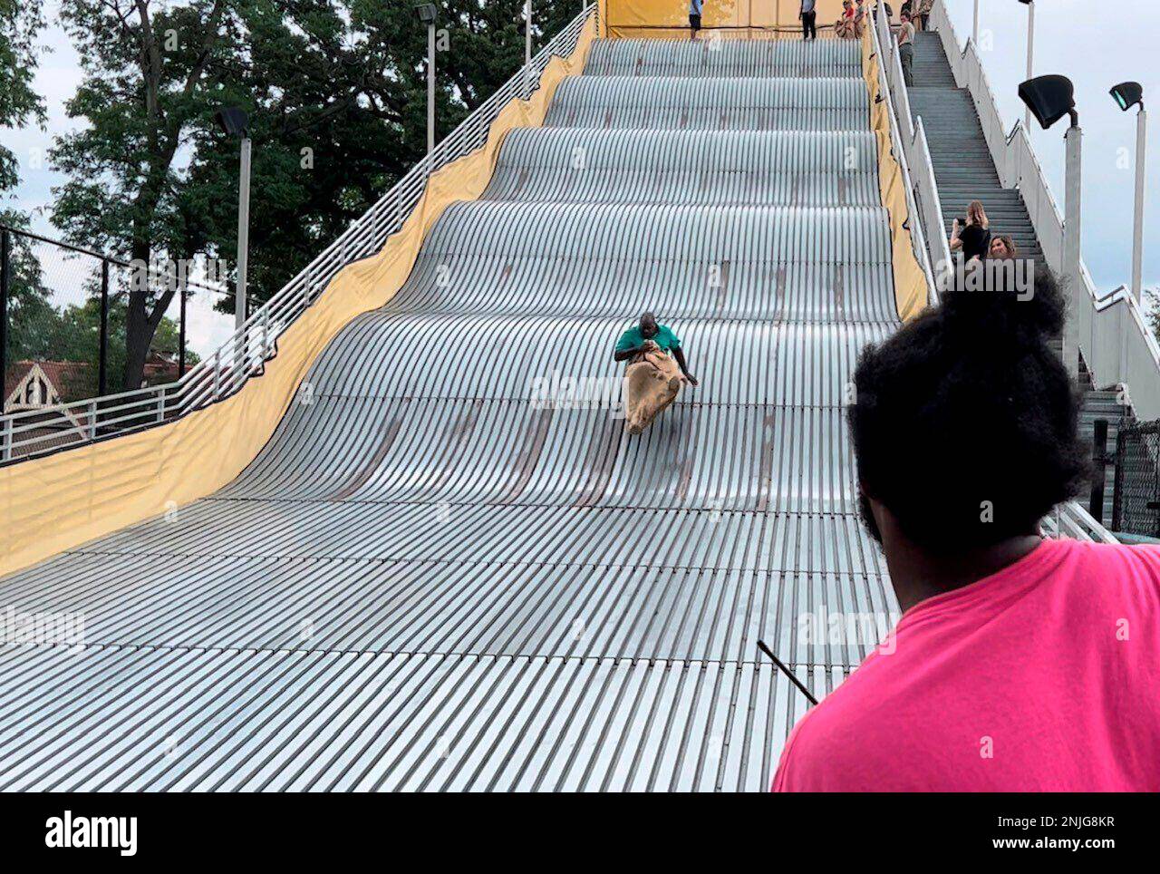A man goes down the giant slide at Belle Isle state park in Detroit on ...