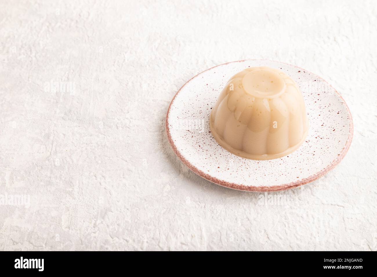 Buckwheat milk jelly on gray concrete background. side view, copy space ...