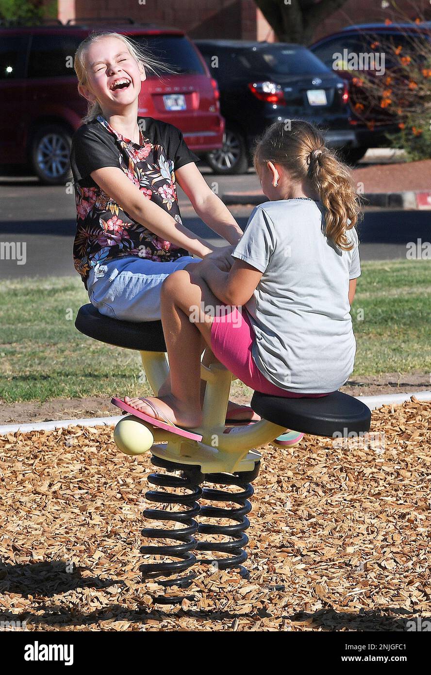 Two young girls enjoy playing on one of the apparatuses at the re ...