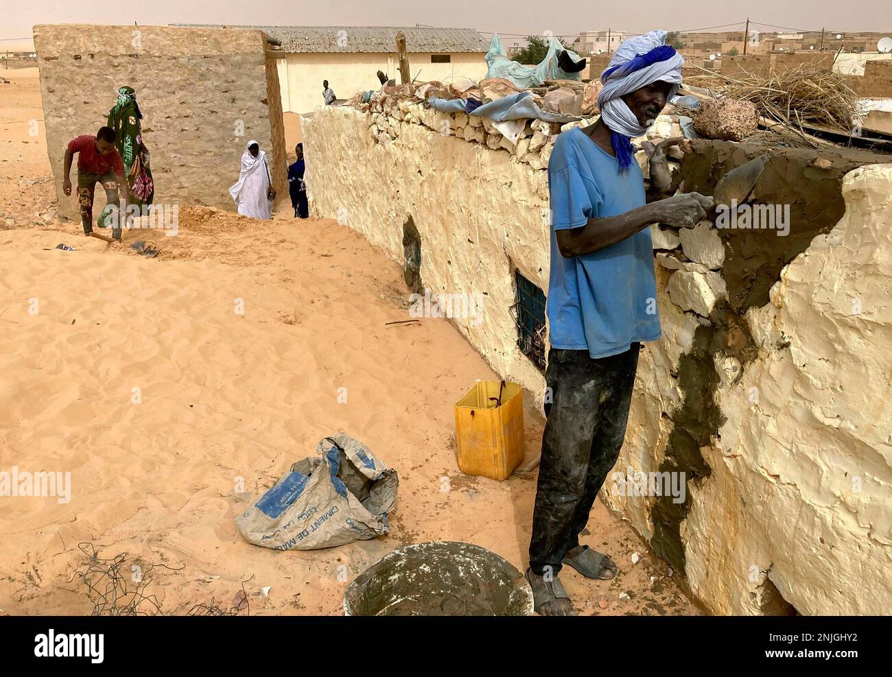 A man mend a roof of a house which is burried in sand in Chinguetti ...