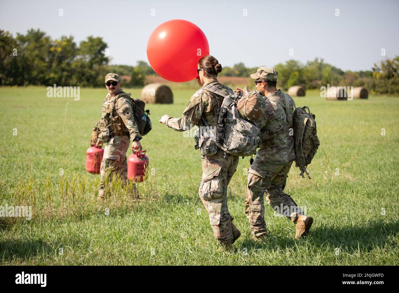 U.S. Army Soldiers carry a large balloon used to measure wind drift ...