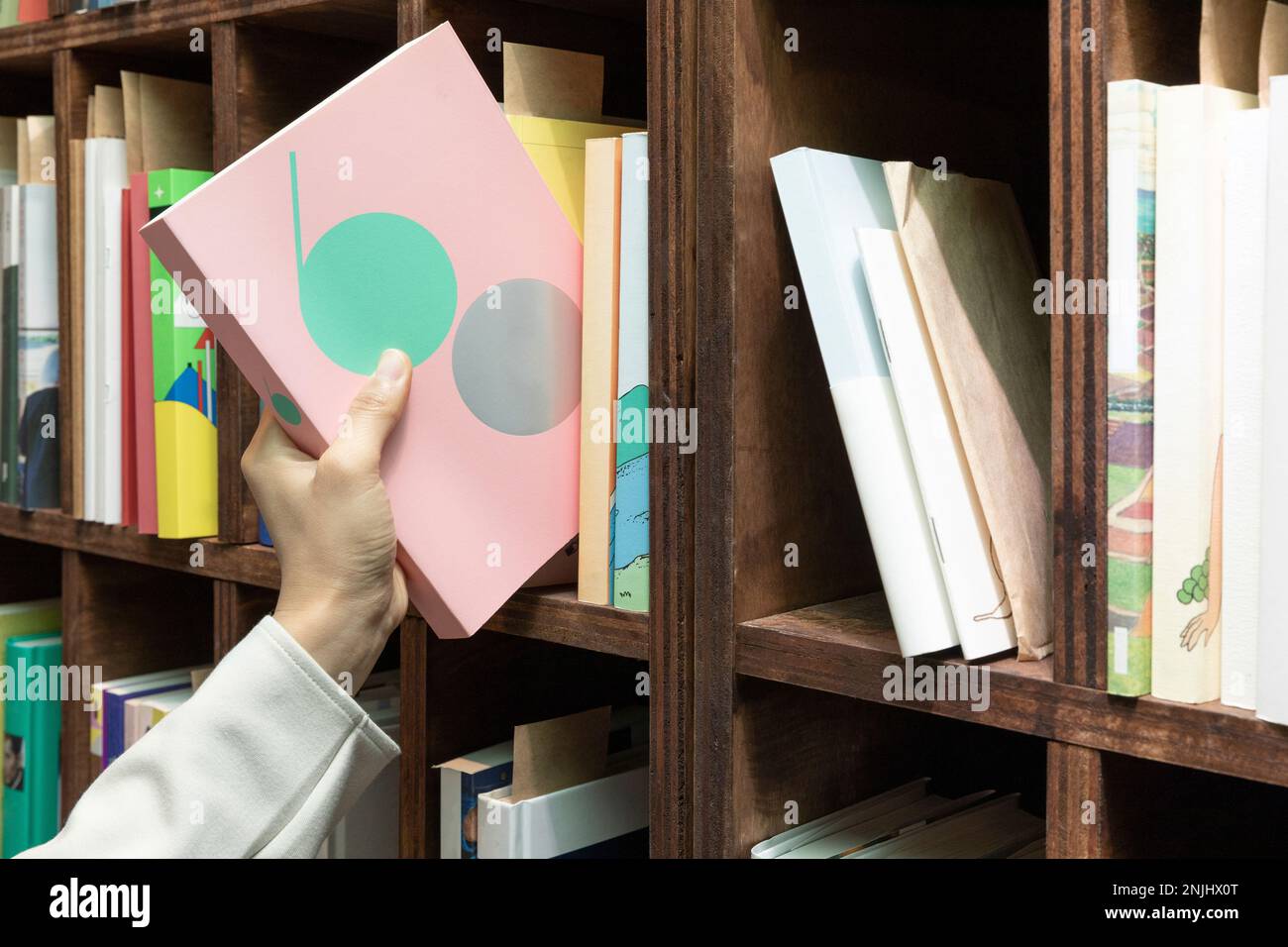 hand selecting, choosing a book Stock Photo - Alamy