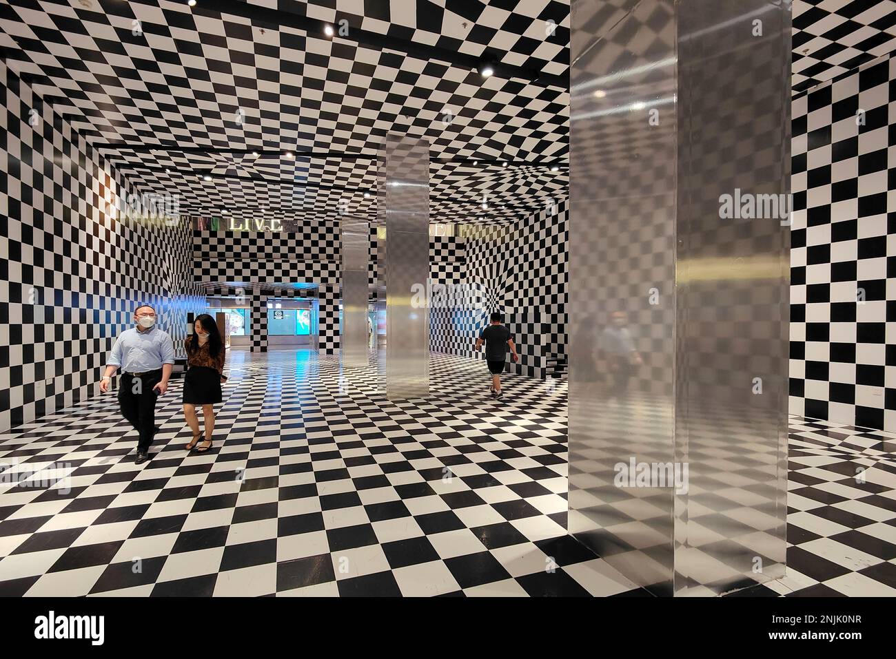 People walk in an checker-board-theme underpass to a department store ...