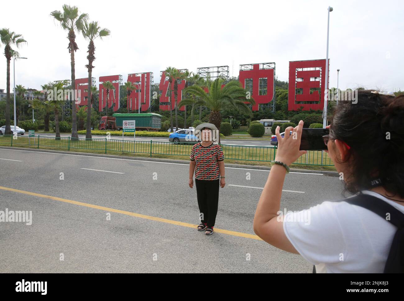 People take a photo in front of a signboard of "one country, two ...