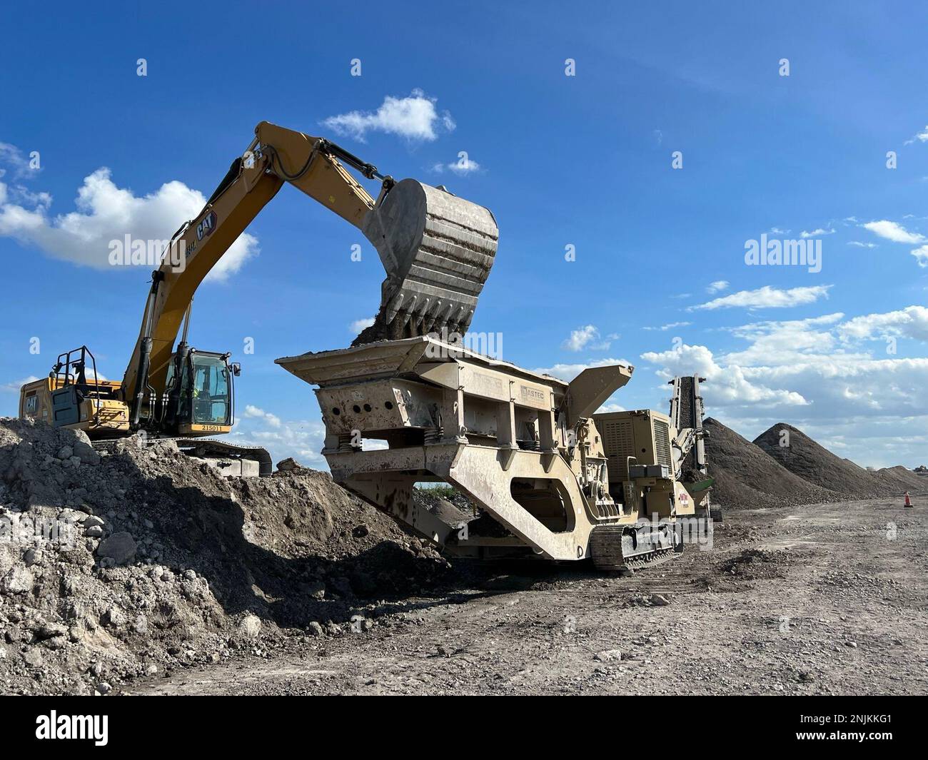 Dirt and rock are loaded into a grinder at the construction area of ...