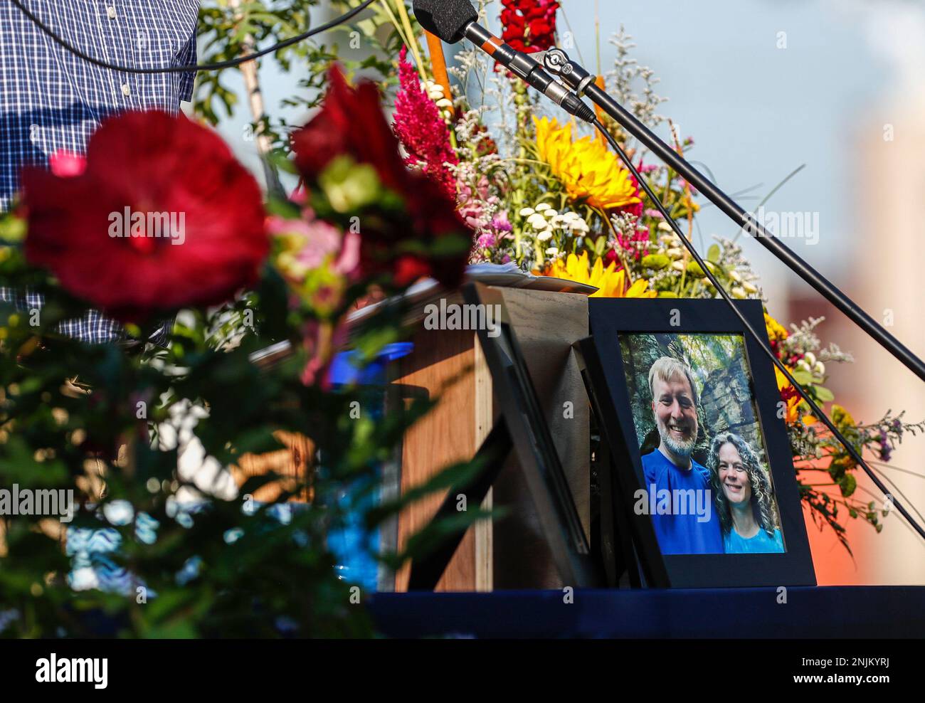 A photo of Tyler and Sarah Schmidt sits on the podium during the ...
