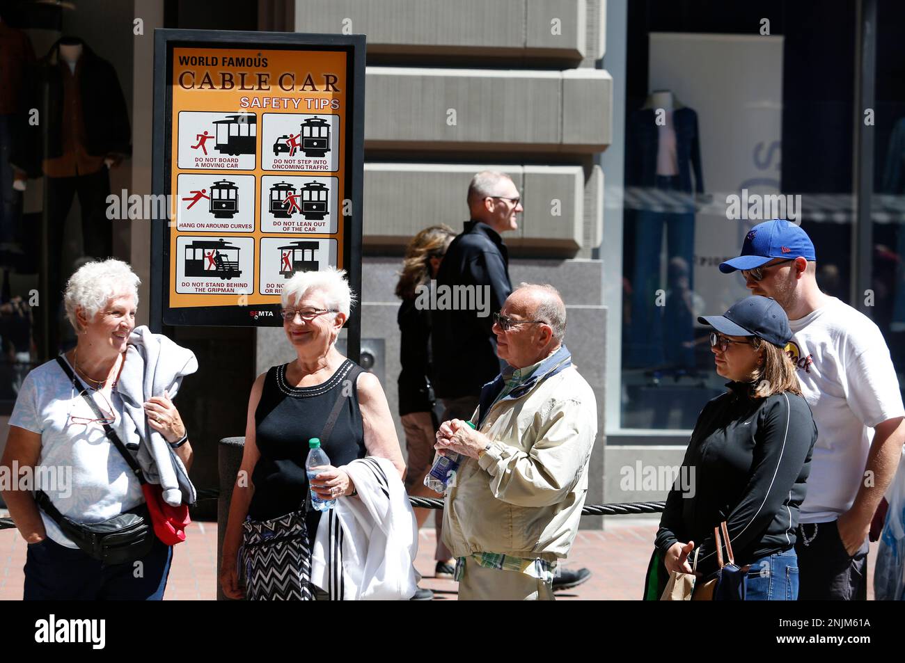 People wait in line to board a cable car at the Powell Street ...