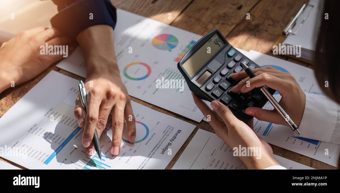 female and male accountant use calculator to calculate the company ...
