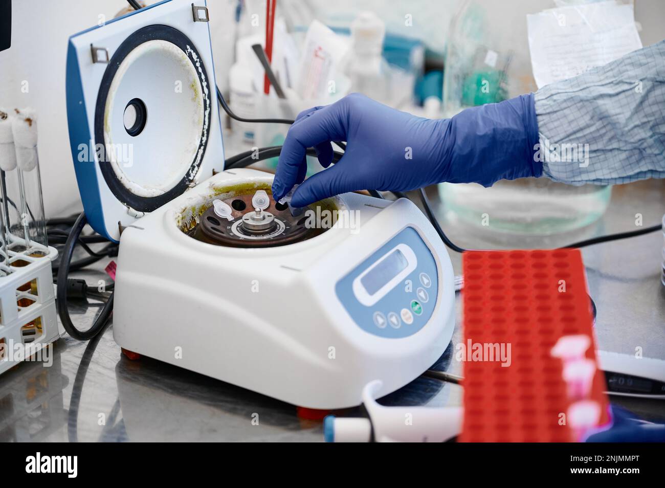 Technician puts test tube with sample into lab centrifuge Stock Photo ...