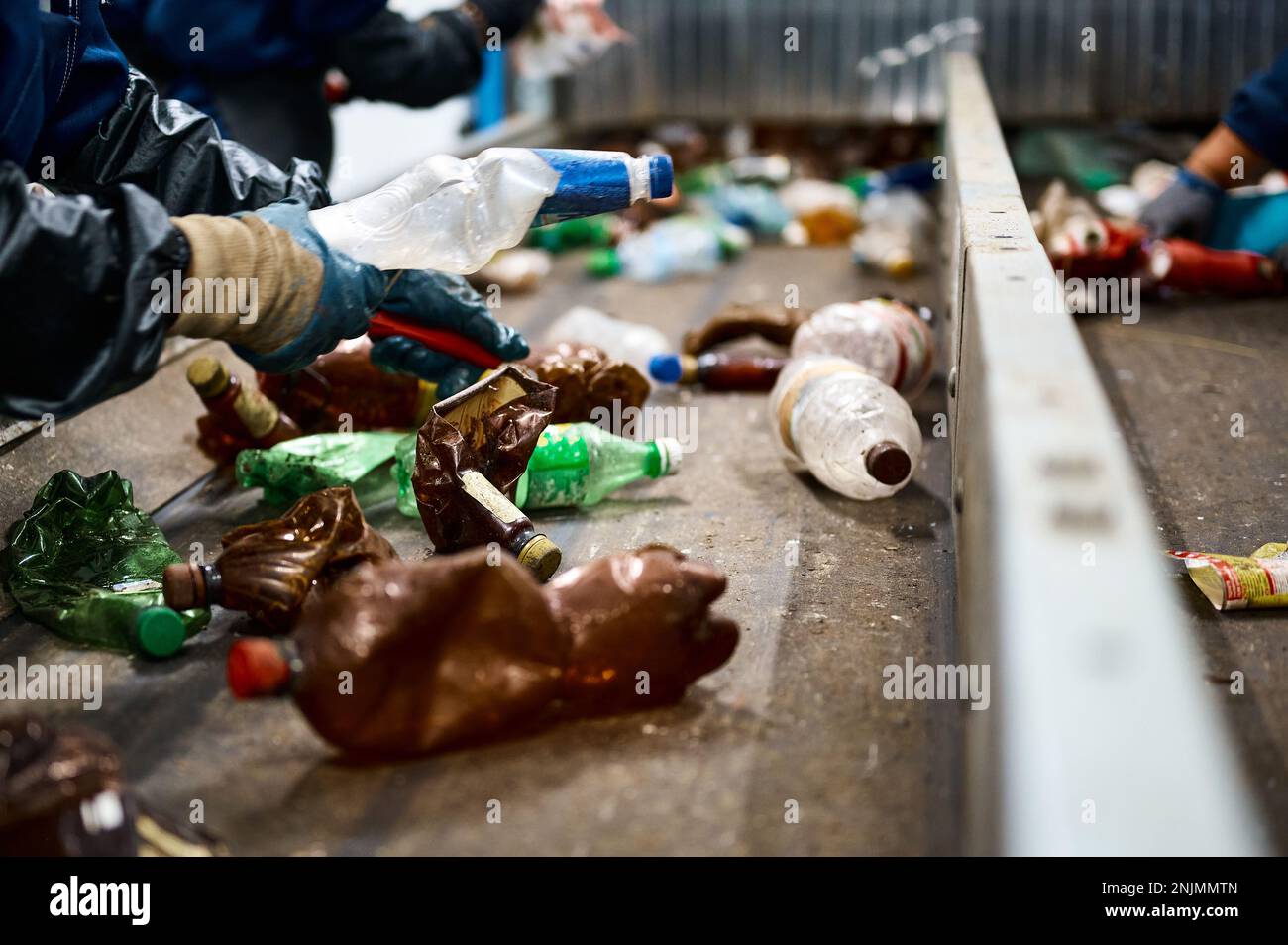 Worker sorts trash on conveyor belt at waste recycling plant Stock Photo - Alamy