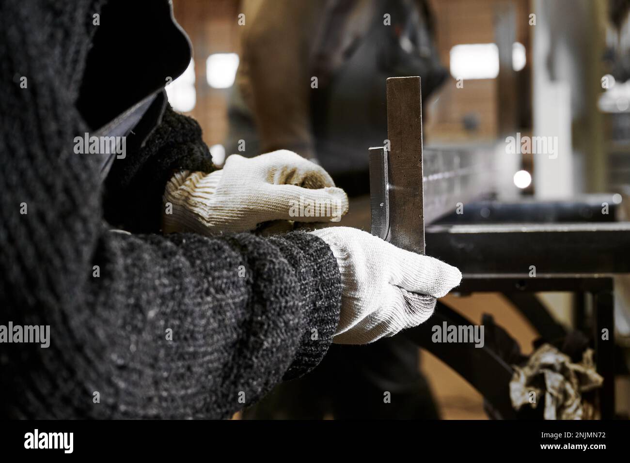 Worker checks bent metal detail corner accuracy with guide Stock Photo ...