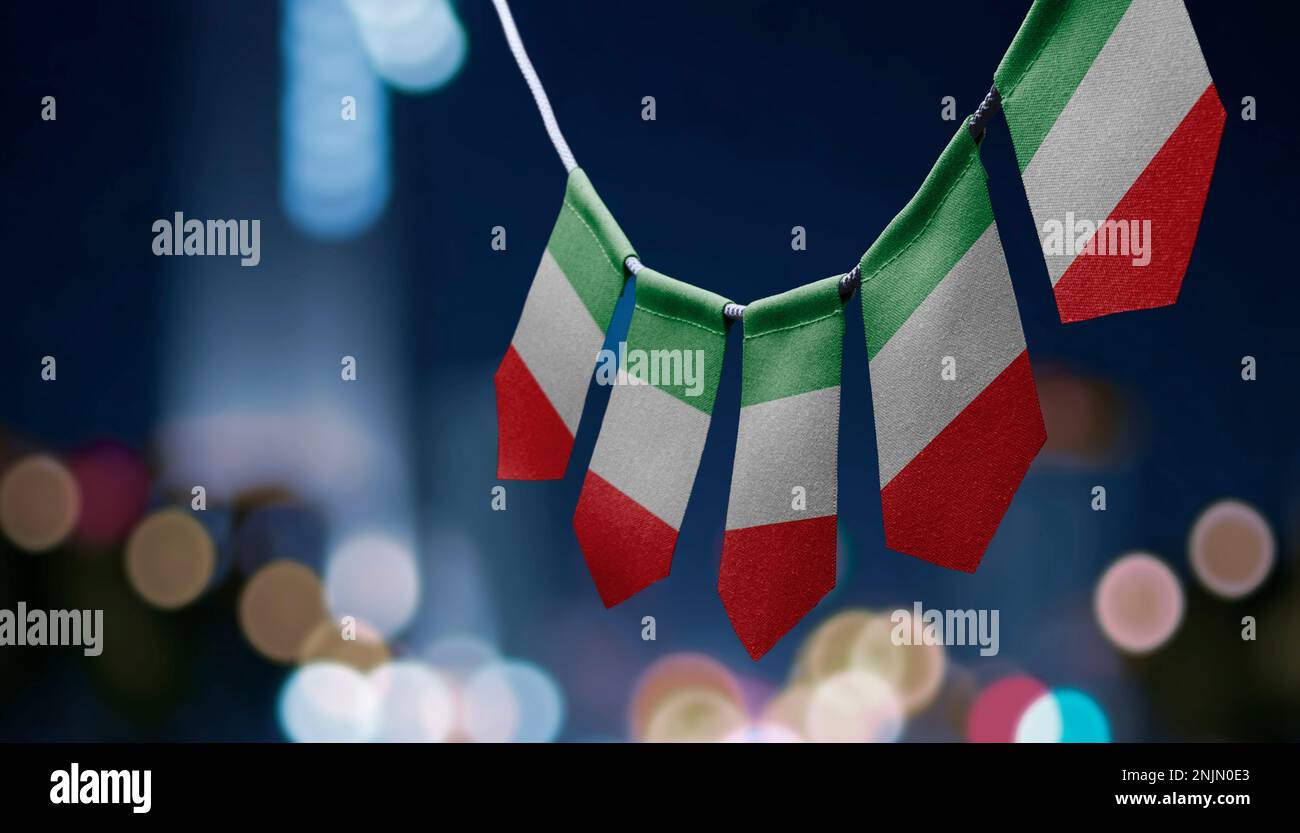A garland of Italy national flags on an abstract blurred background ...