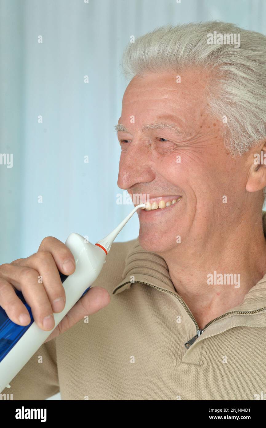 Portrait of a old man cleaning teeth Stock Photo - Alamy