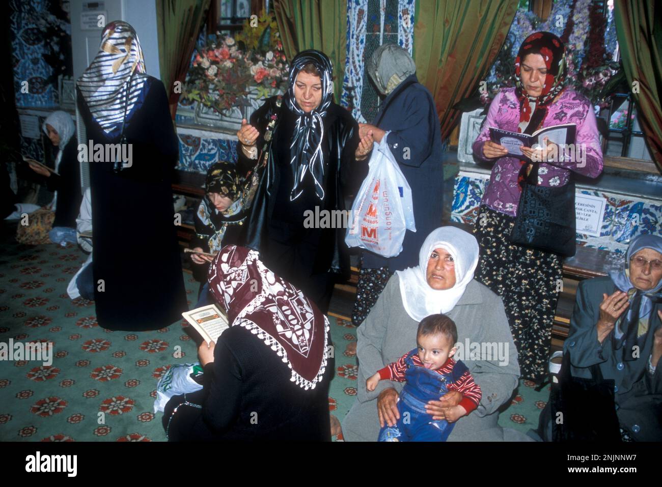 Women pilgrim pray at the Eyup Sultan shrine, Golden Horn, Istanbul ...