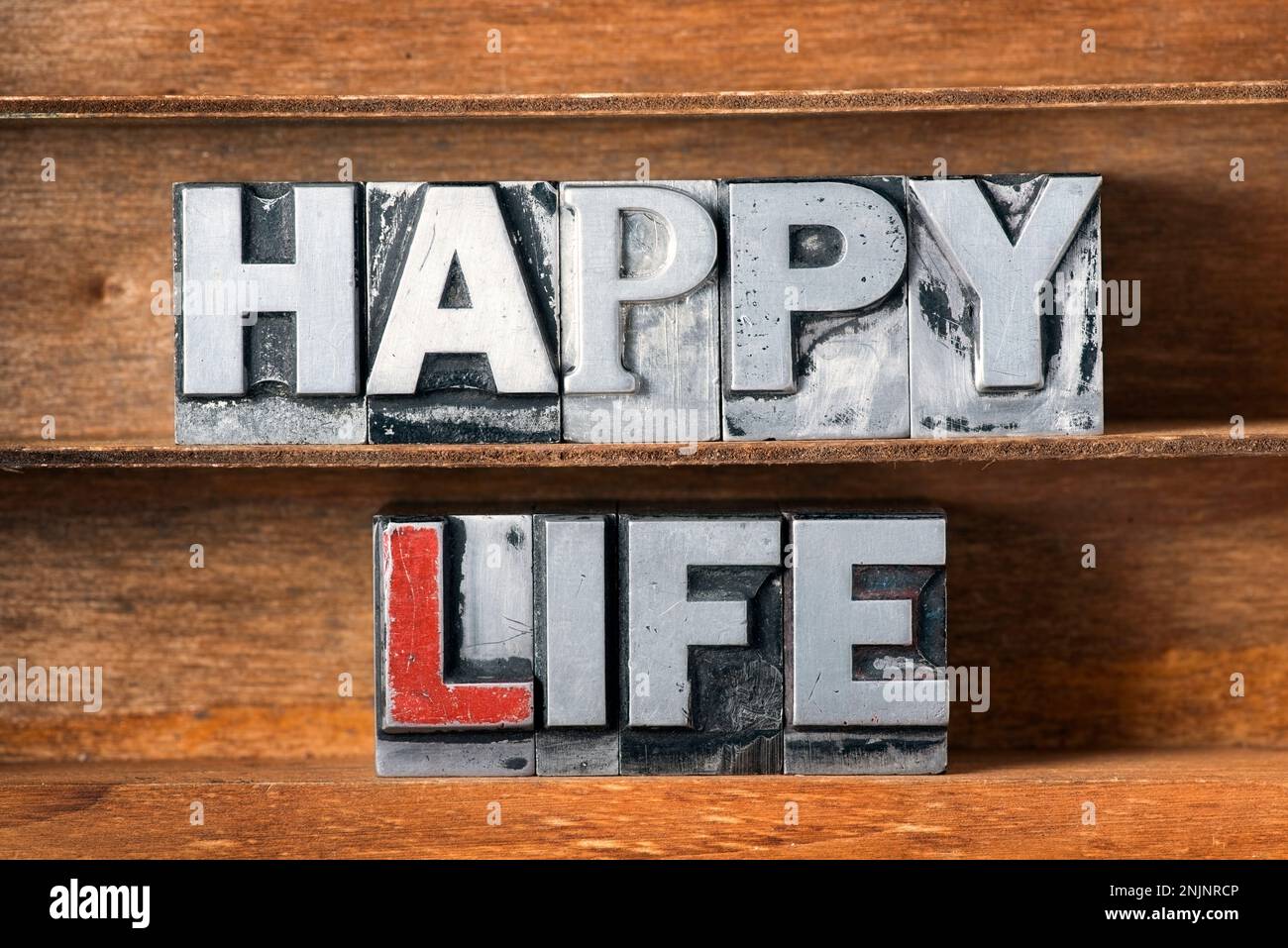 happy life phrase made from metallic letterpress type on wooden tray ...