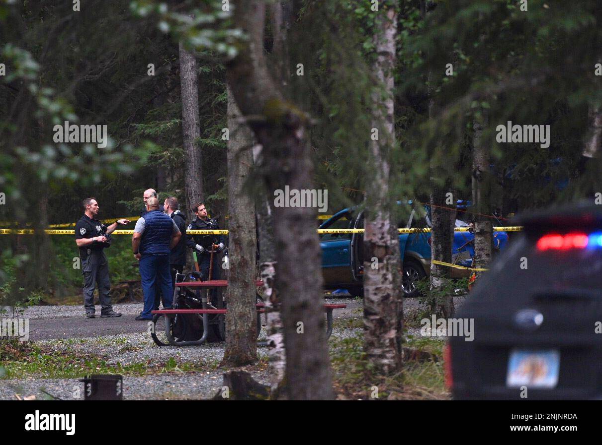 Law enforcement officers investigate the scene of a shooting in ...