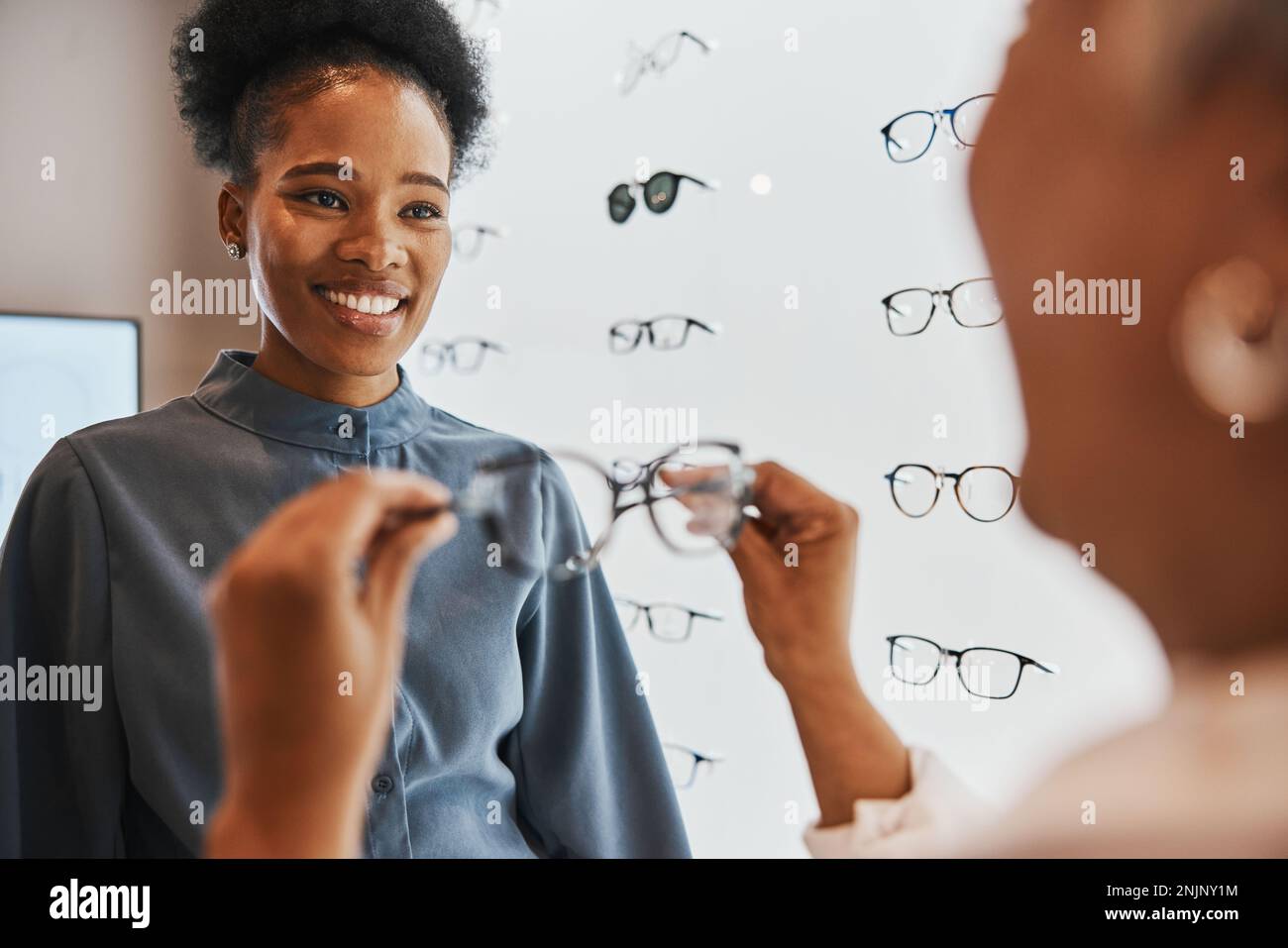 Glasses, black woman and retail customer with store worker and optician ...