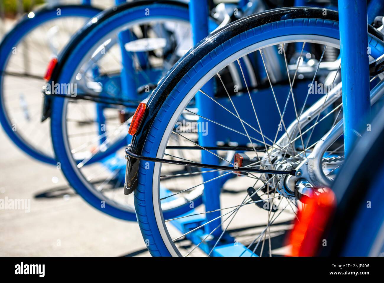 Row of bright blue bicycles ready for rent and urban city trips are ...