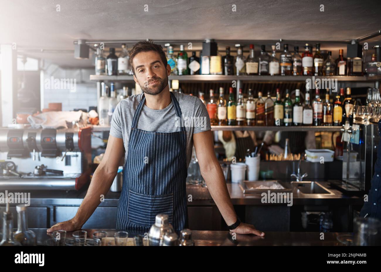 The best bar by far. Portrait of a confident young man working behind a ...