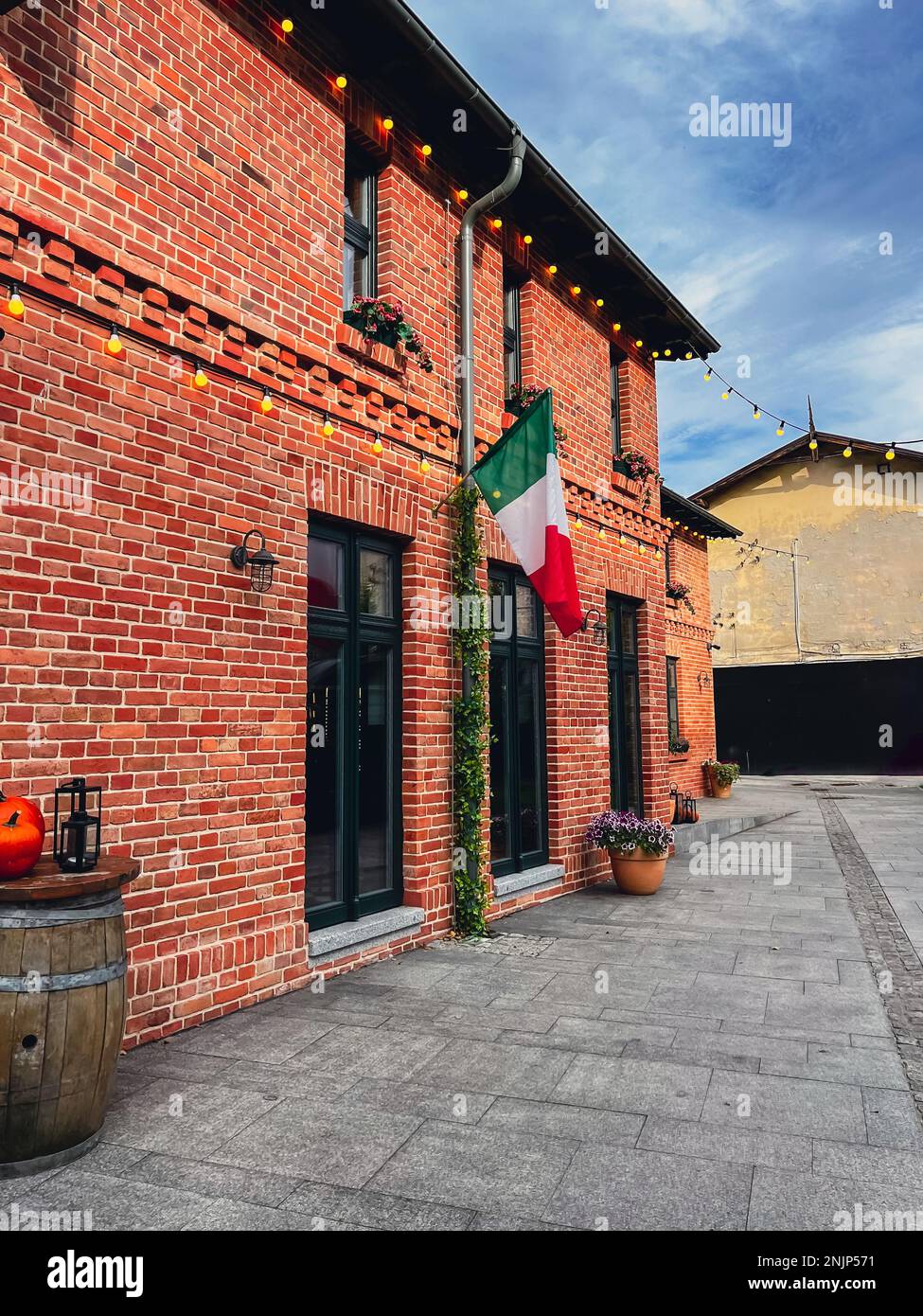 Italian flag on rick row house. Facade of brick building with Italian ...
