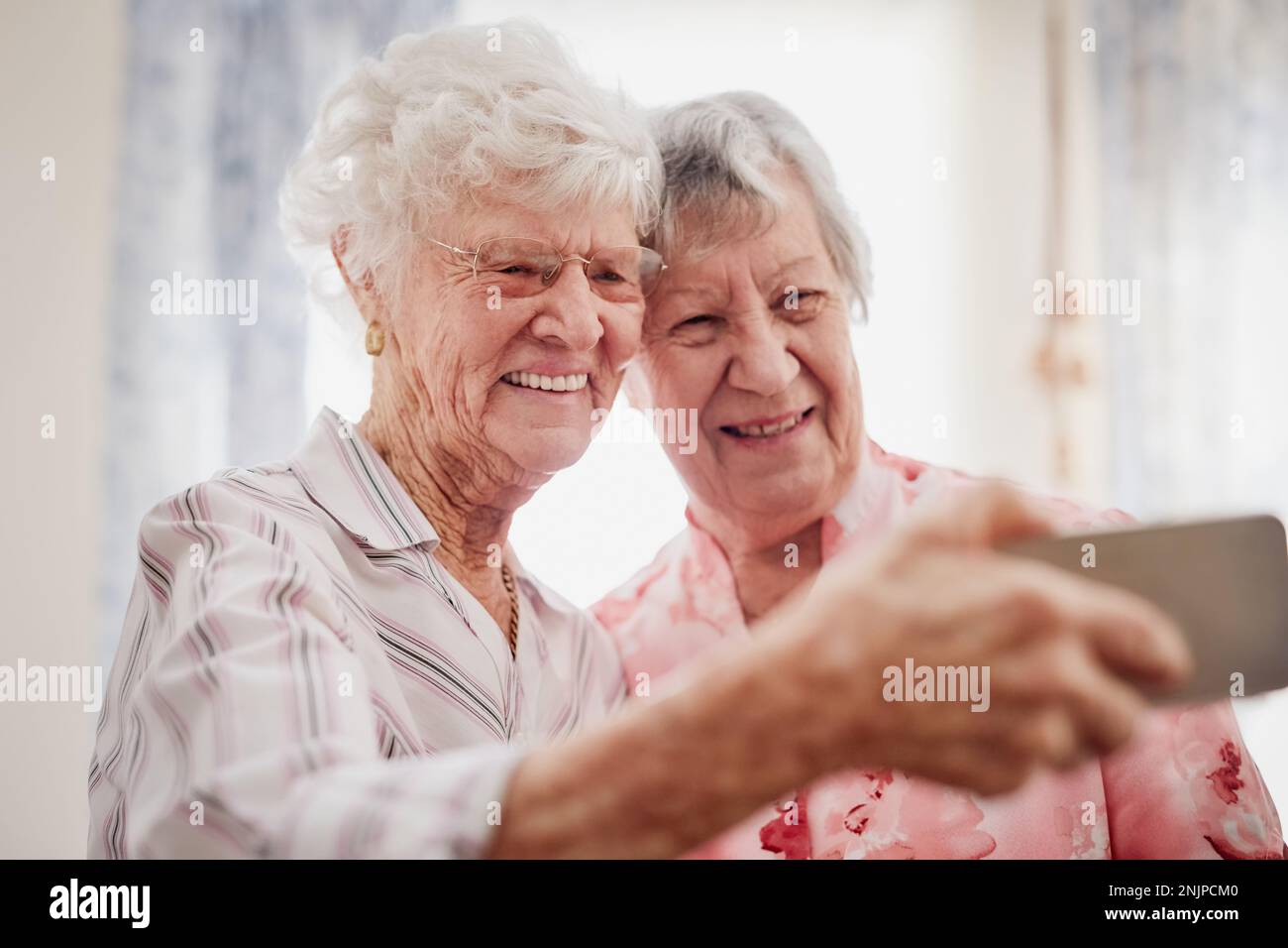 Adding to their collection of life long memories. Portrait of two happy elderly women taking ...