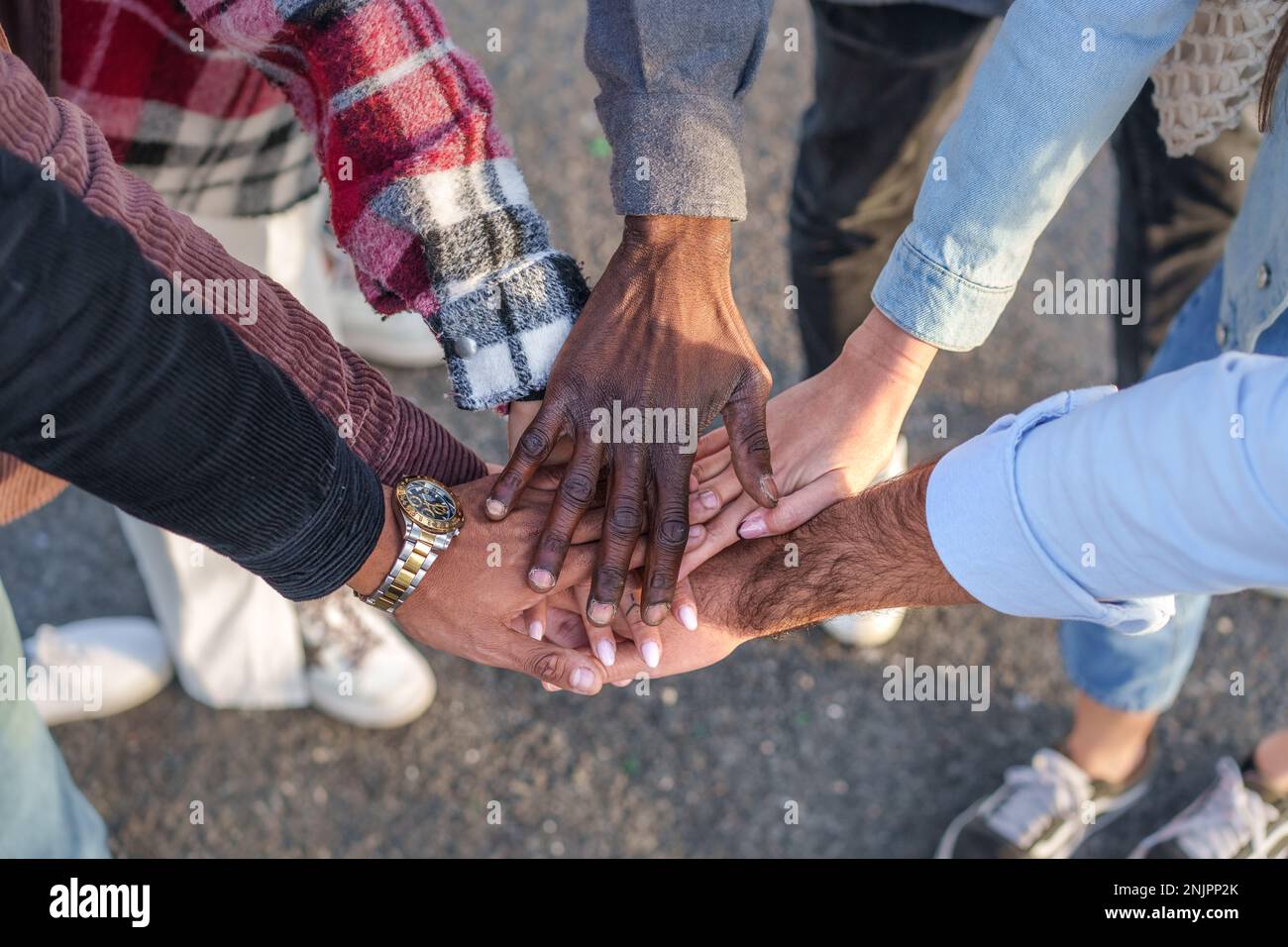 A group of friends join hands in a circle, representing unity and ...