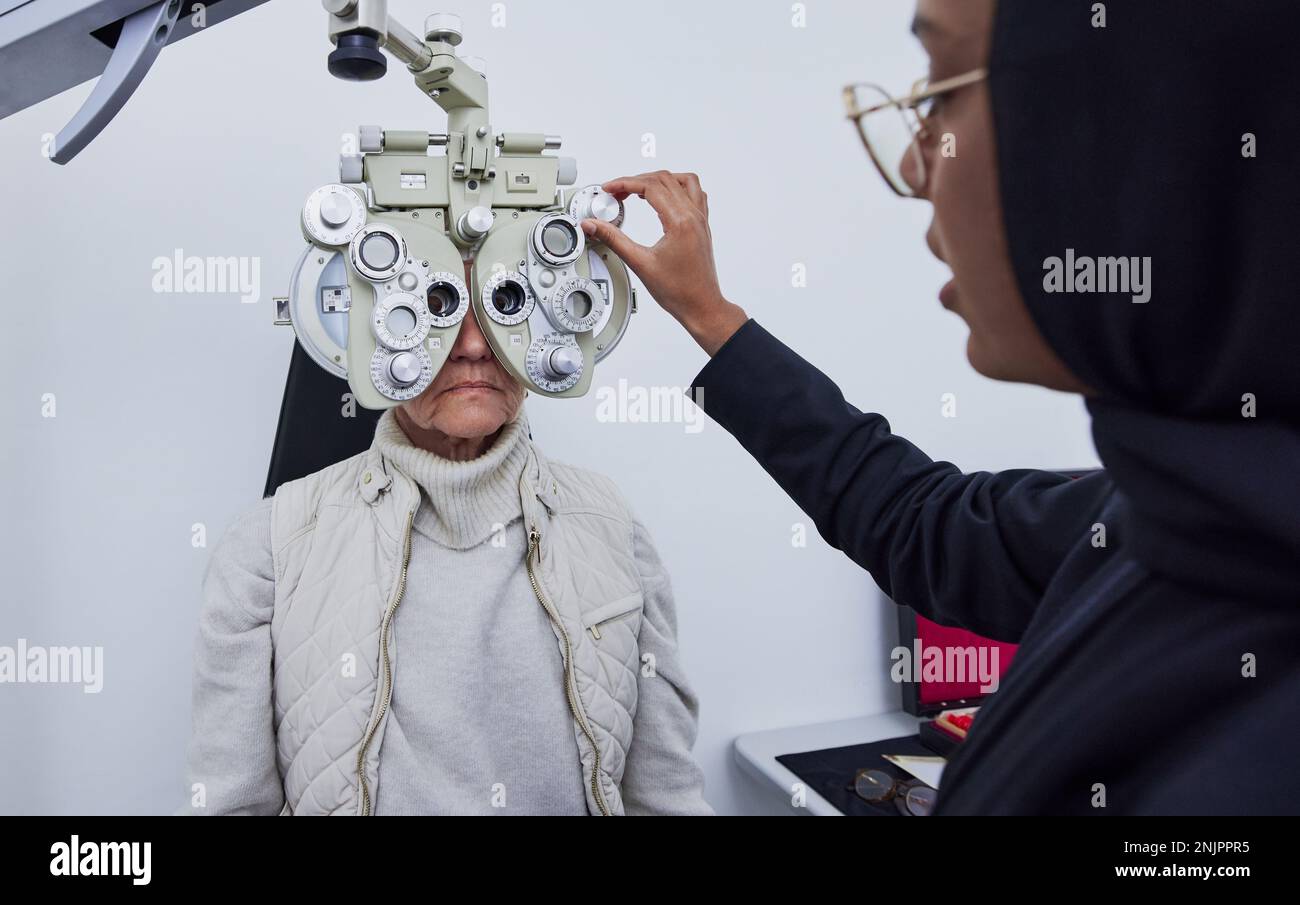 Eye exam, vision and woman with Muslim optometrist in clinic for test ...