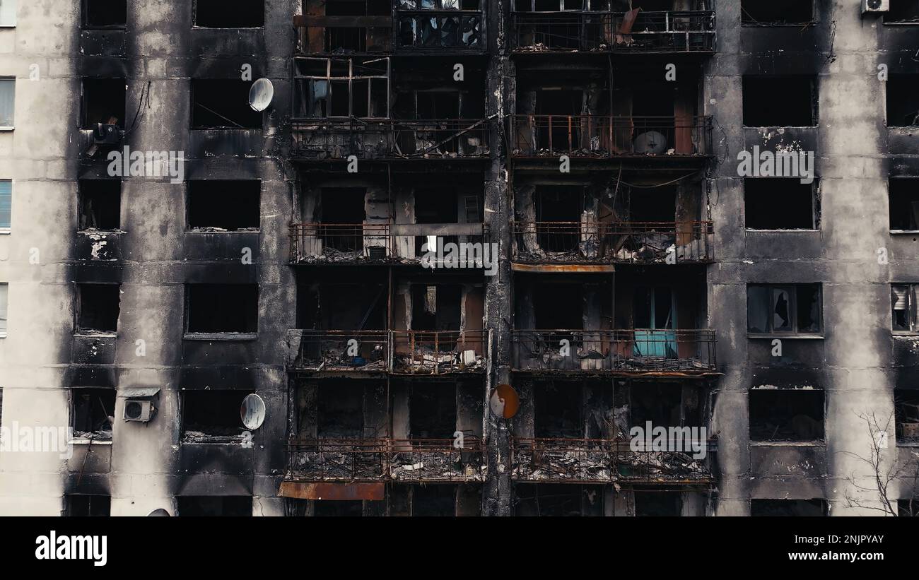 A burnt-out high-rise in the war zone. Damage to a residential building ...