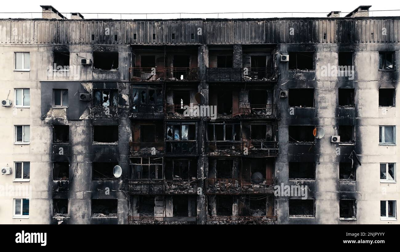 A burnt-out high-rise in the war zone. Damage to a residential building ...