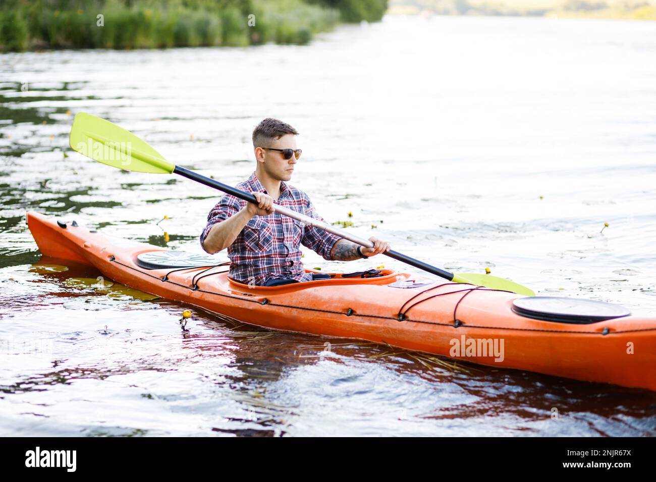 Kayaking on the river. A young Caucasian man sits in a kayak and ...