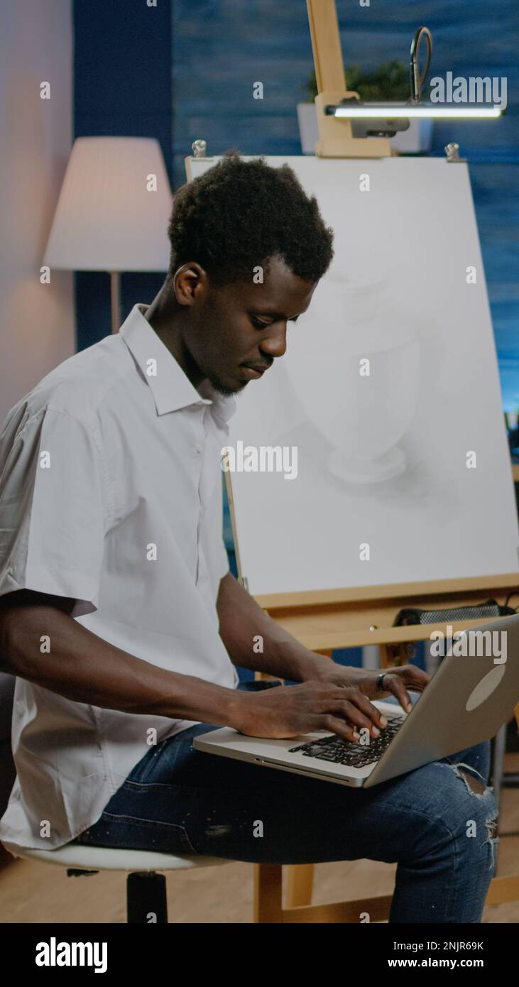 African american artist man searching inspiration on laptop computer ...