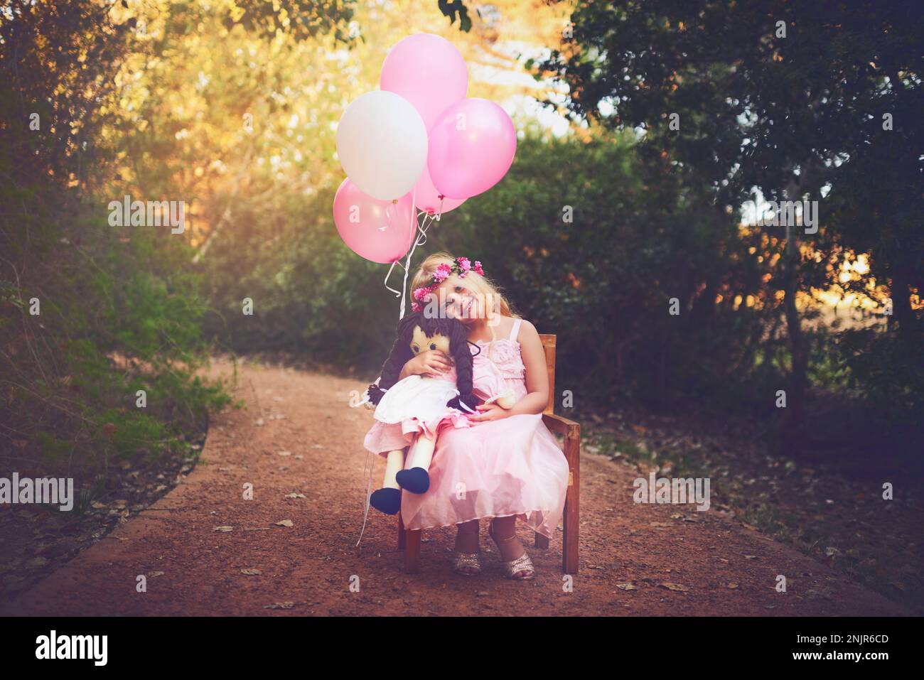 I love my dolly. a happy little girl sitting and waiting with a doll ...
