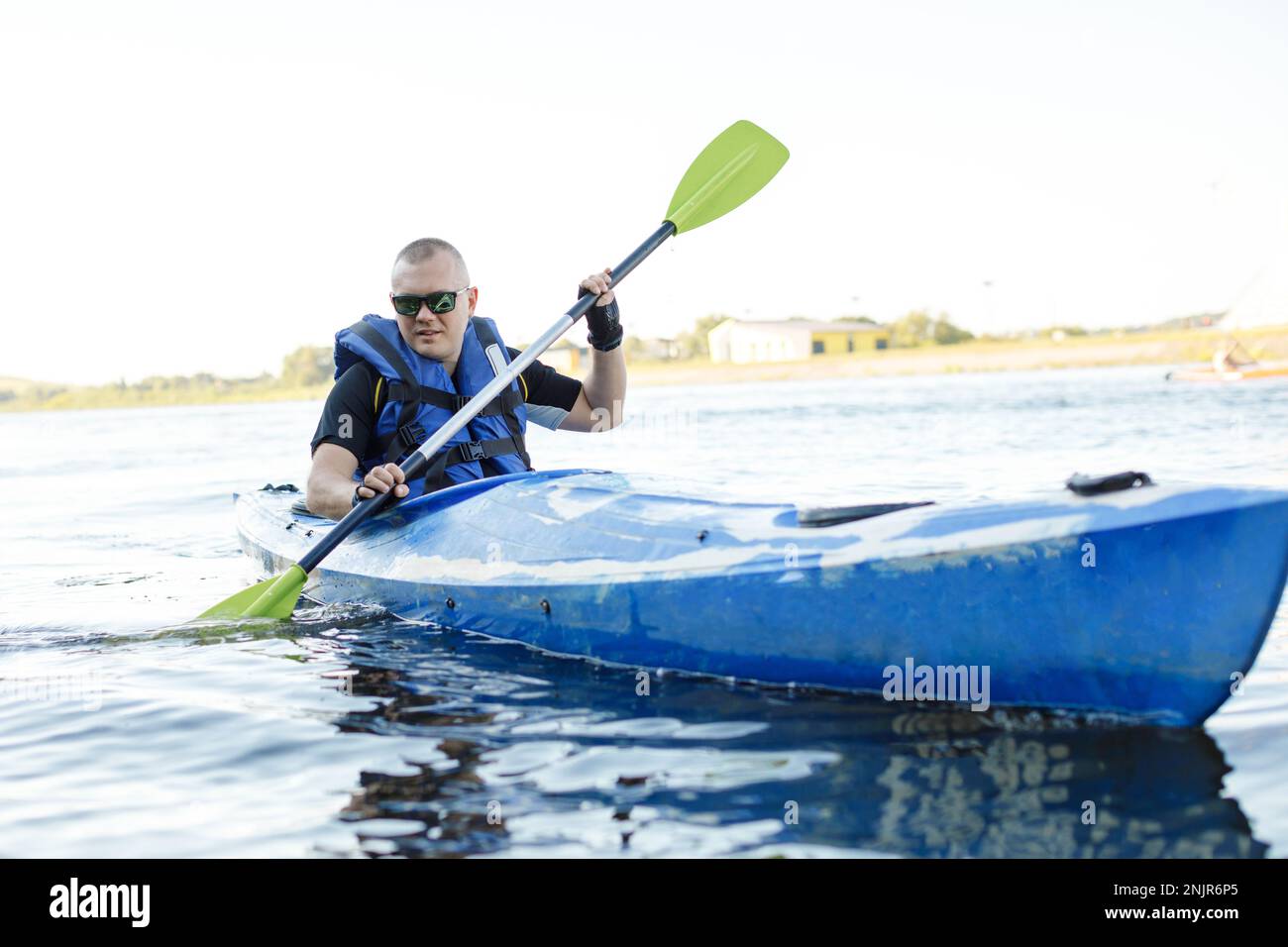 Kayaking on the river. A young Caucasian man sits in a kayak and ...