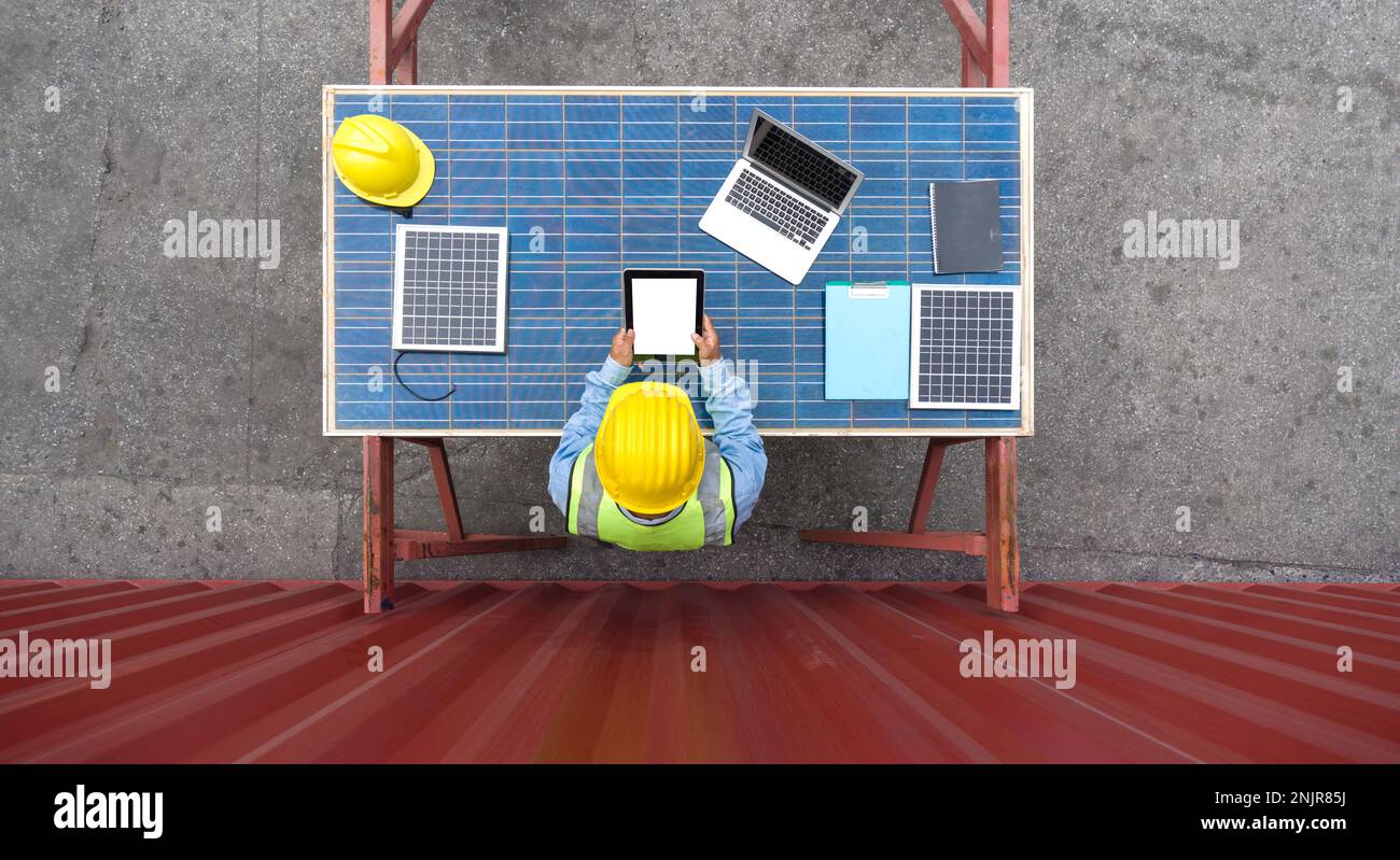 Shipment worker in hardhat and safety vest looking at white screen ...