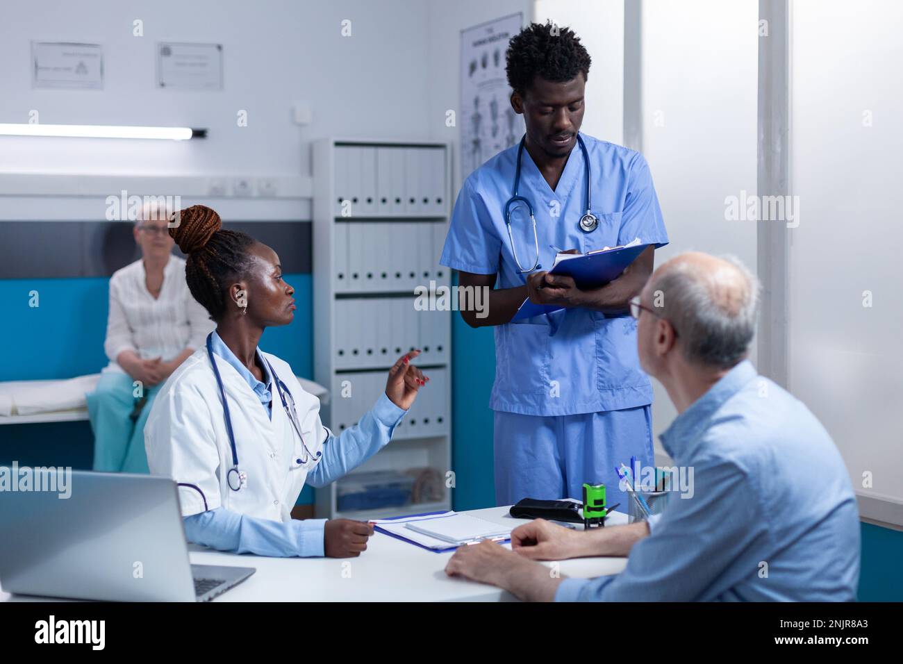 African american healthcare hospital staff reviewing senior patient ...