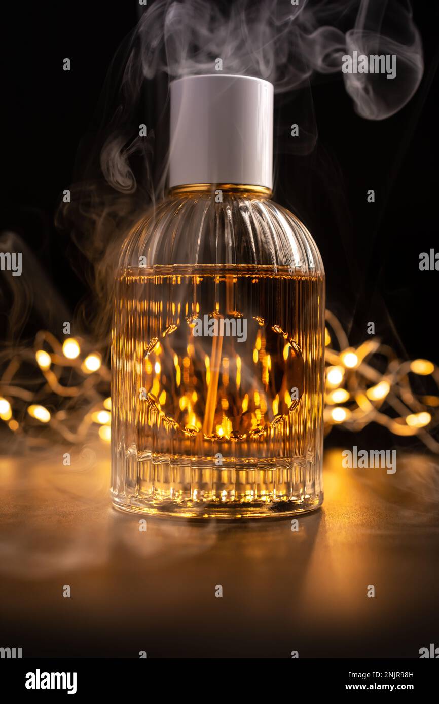 Mock-up of cosmetic product. Glass bottle of perfume with smoke on ...