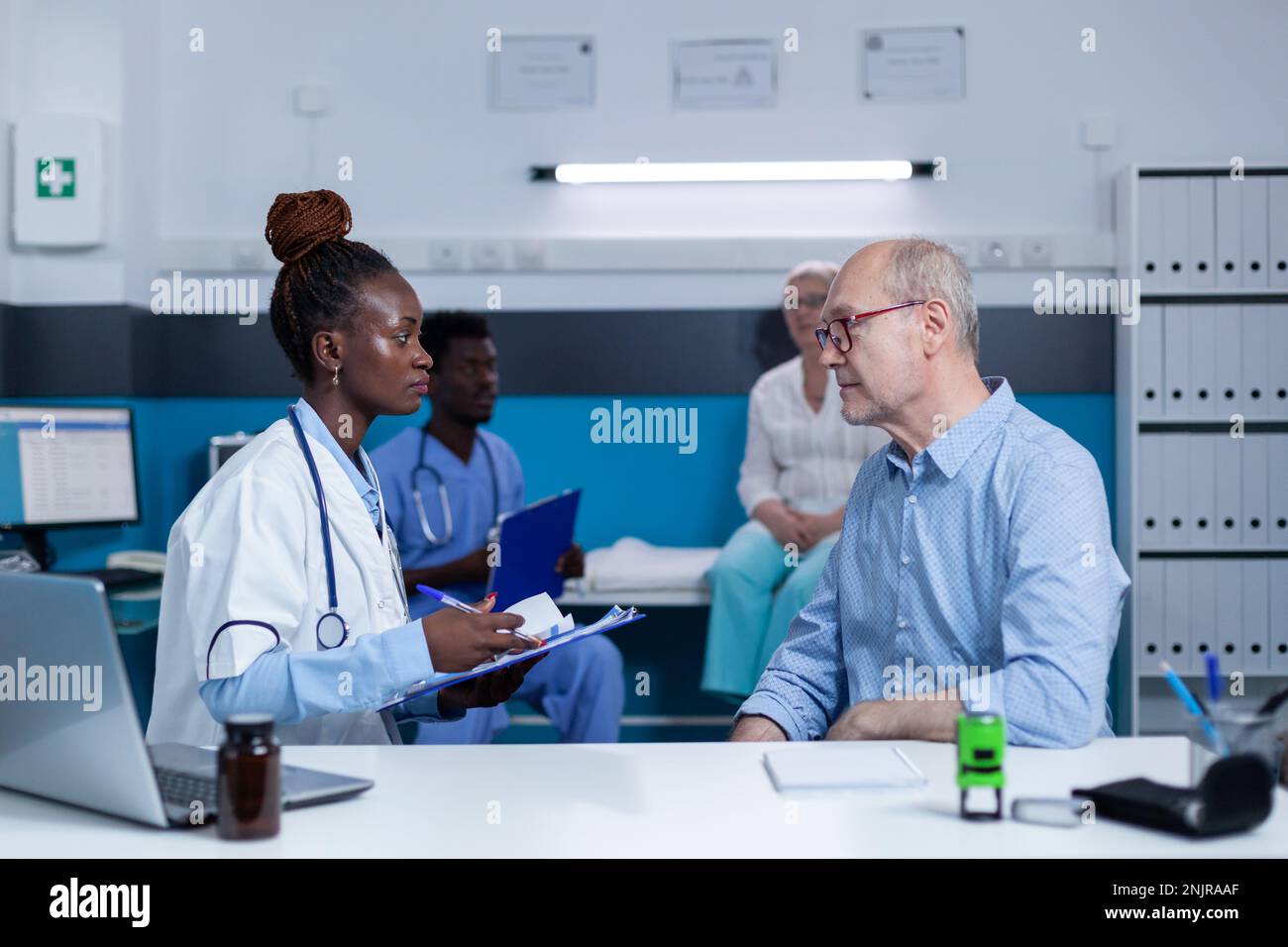Healthcare clinic specialist taking notes about sick elderly patient ...