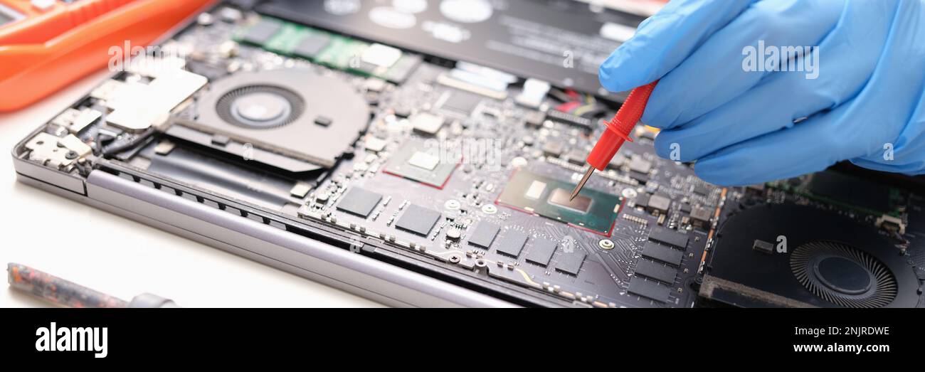Technician measures the voltage on motherboard of computer electronic ...
