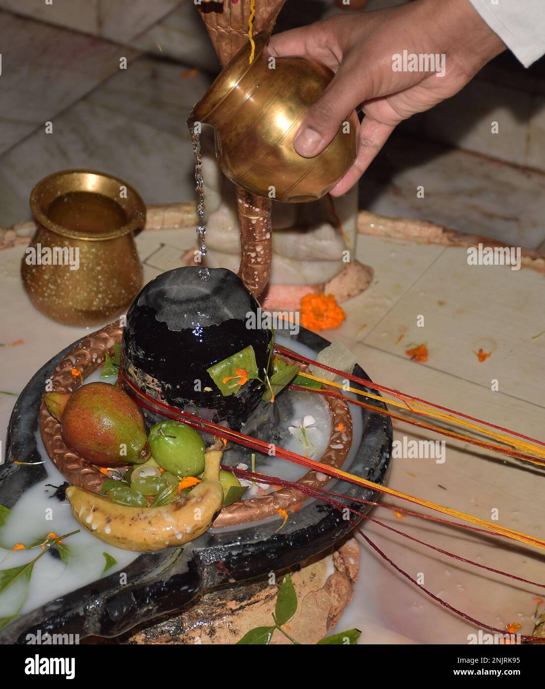 Hand of a devotee Offering water to Shivling or Lord Shiva on the ...