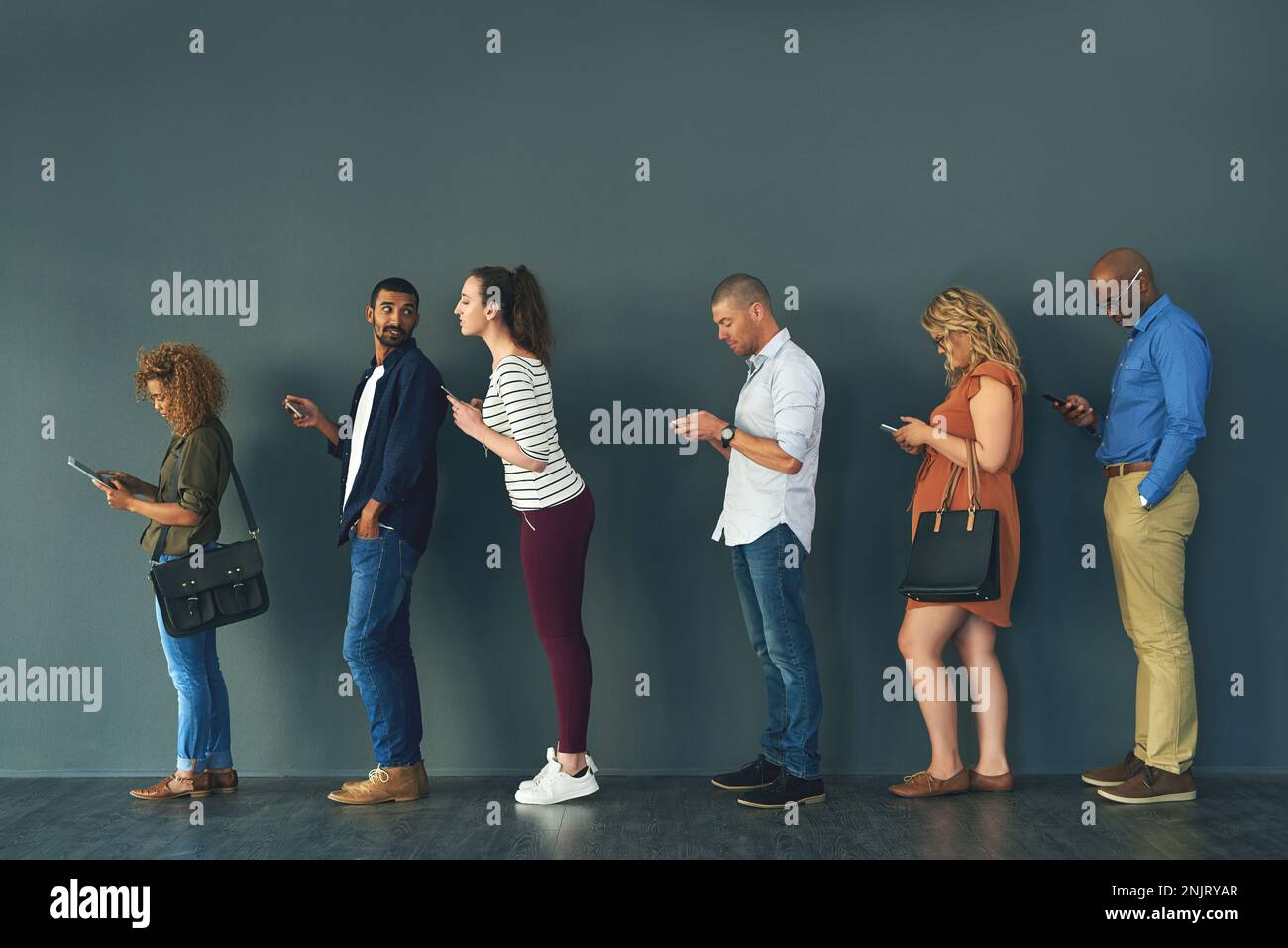 We are one with technology. a group of people standing in a row behind ...